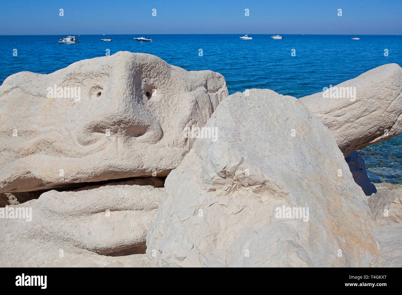 Large face carved into rocks on a pier Stock Photo - Alamy