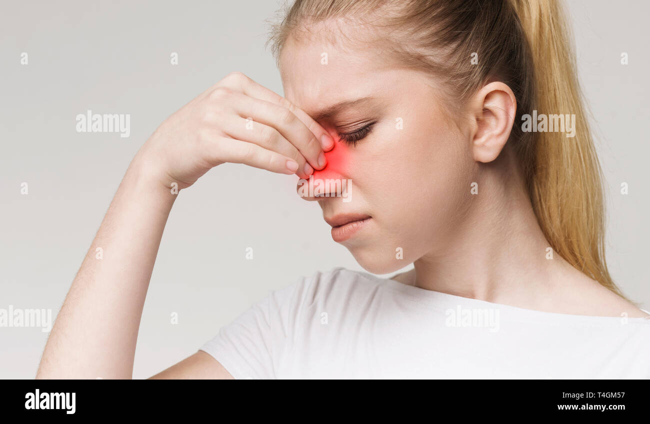 Sad woman holding nose because sinus pain Stock Photo - Alamy
