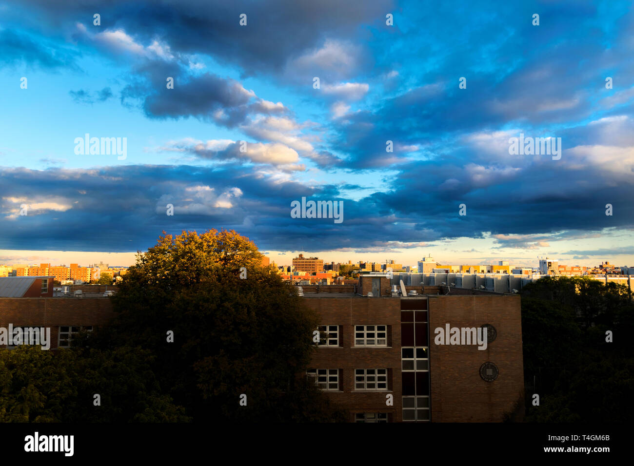 Dramatic clouds moving across a blue sky while the setting sun adds a ...