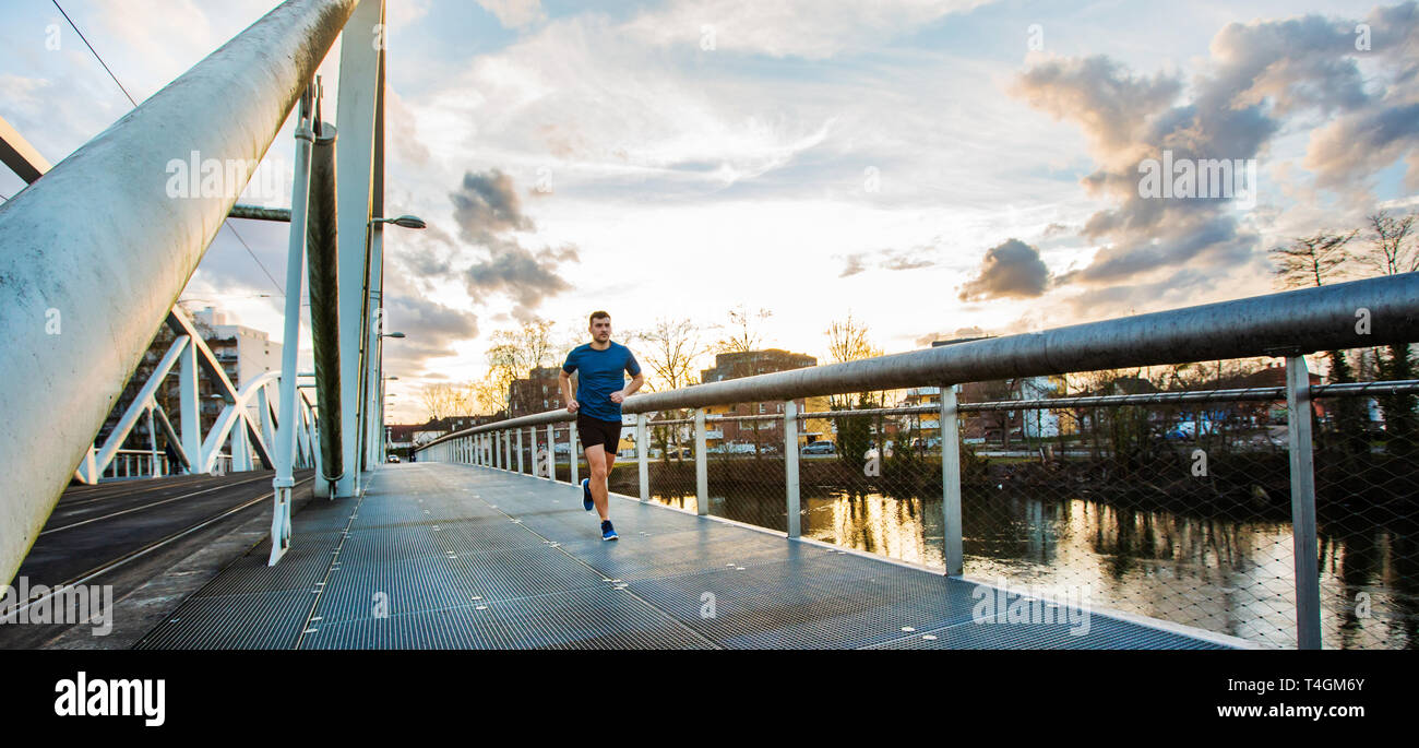 Running man runner training doing outdoor city run sprinting over a ...