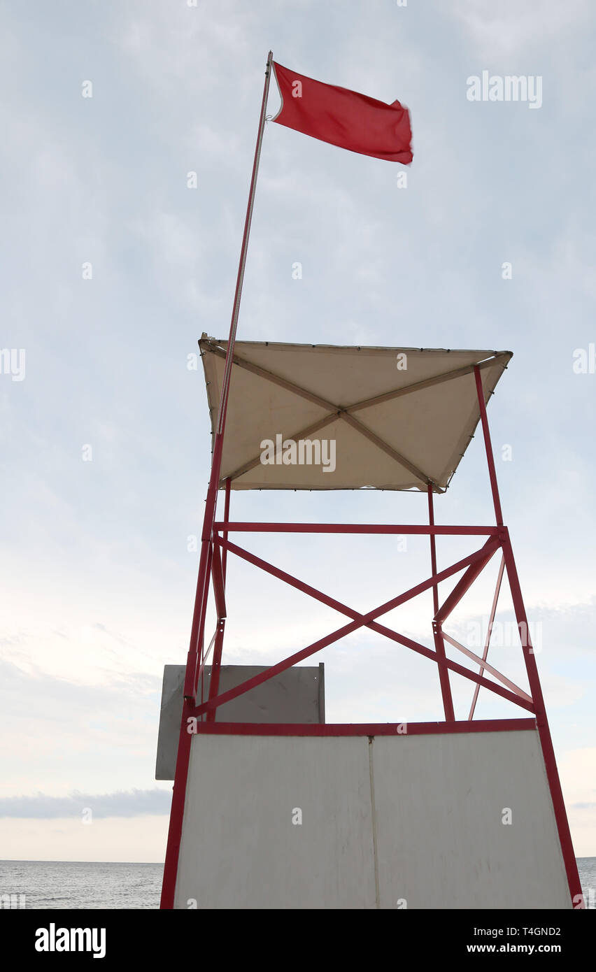 big red flag symbol of danger of warning in the turret on the beach ...