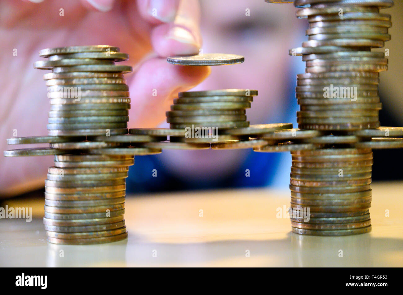 stacking gold dollar coins into bridge Stock Photo - Alamy