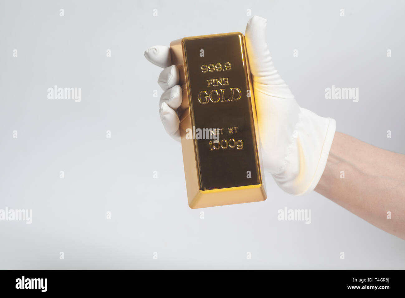 Men's hand in white gloves holding a gold bullion Stock Photo - Alamy