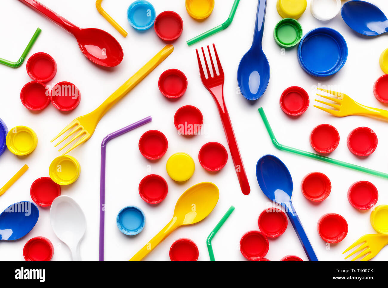 Colored single use plastic and other plastic items on white background ...