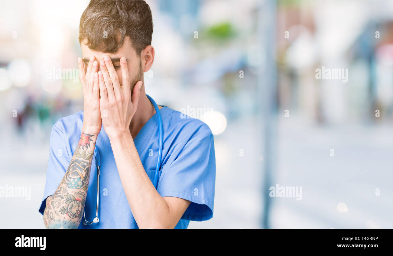 Young handsome nurse man wearing surgeon uniform over isolated ...
