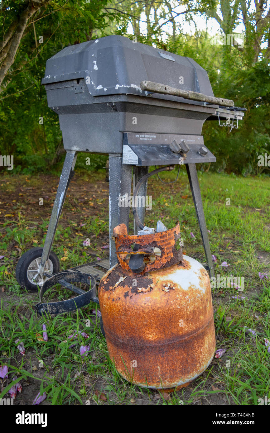 Old and very rusty propane canister and outdoor grill Stock Photo - Alamy