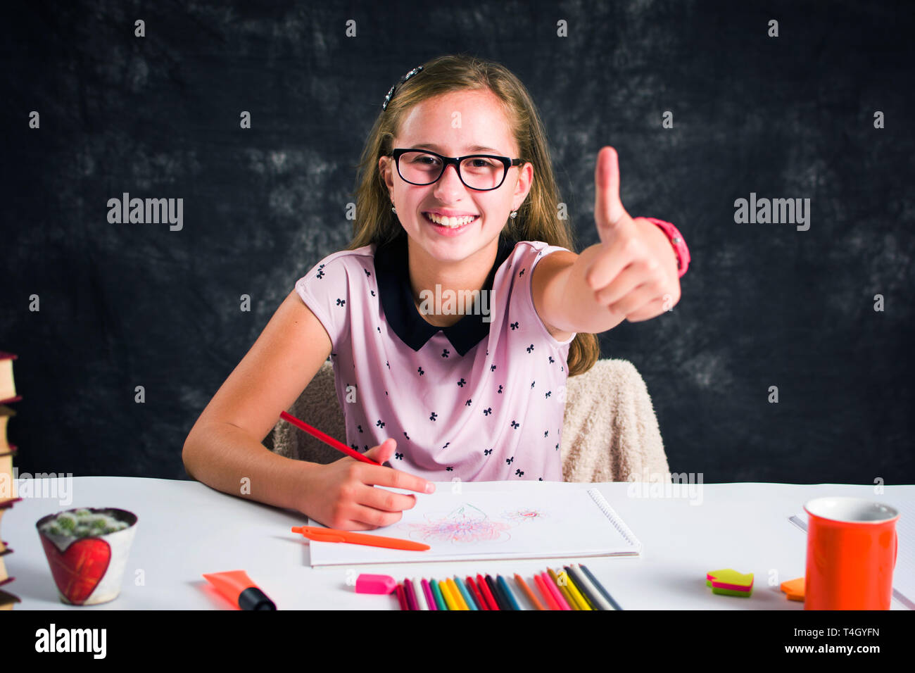 Happy girl drawing a flower with colorful pencils Stock Photo - Alamy