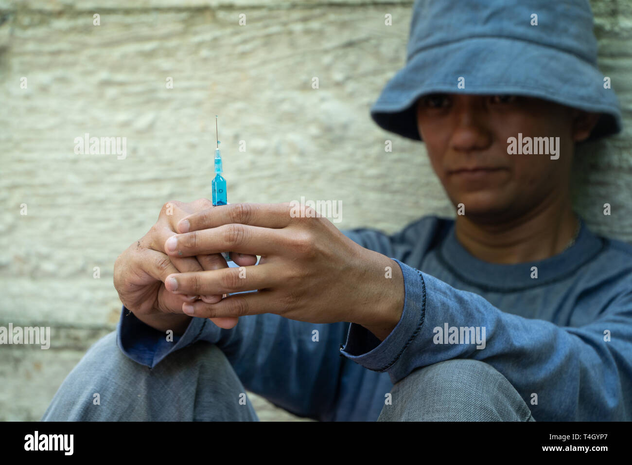 close up of Syringe and Needle in hand of drug addict man. homeless ...