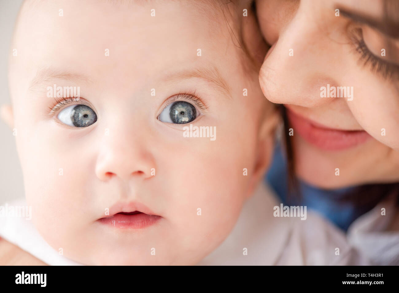 Mother whisper to baby ear close up Stock Photo - Alamy