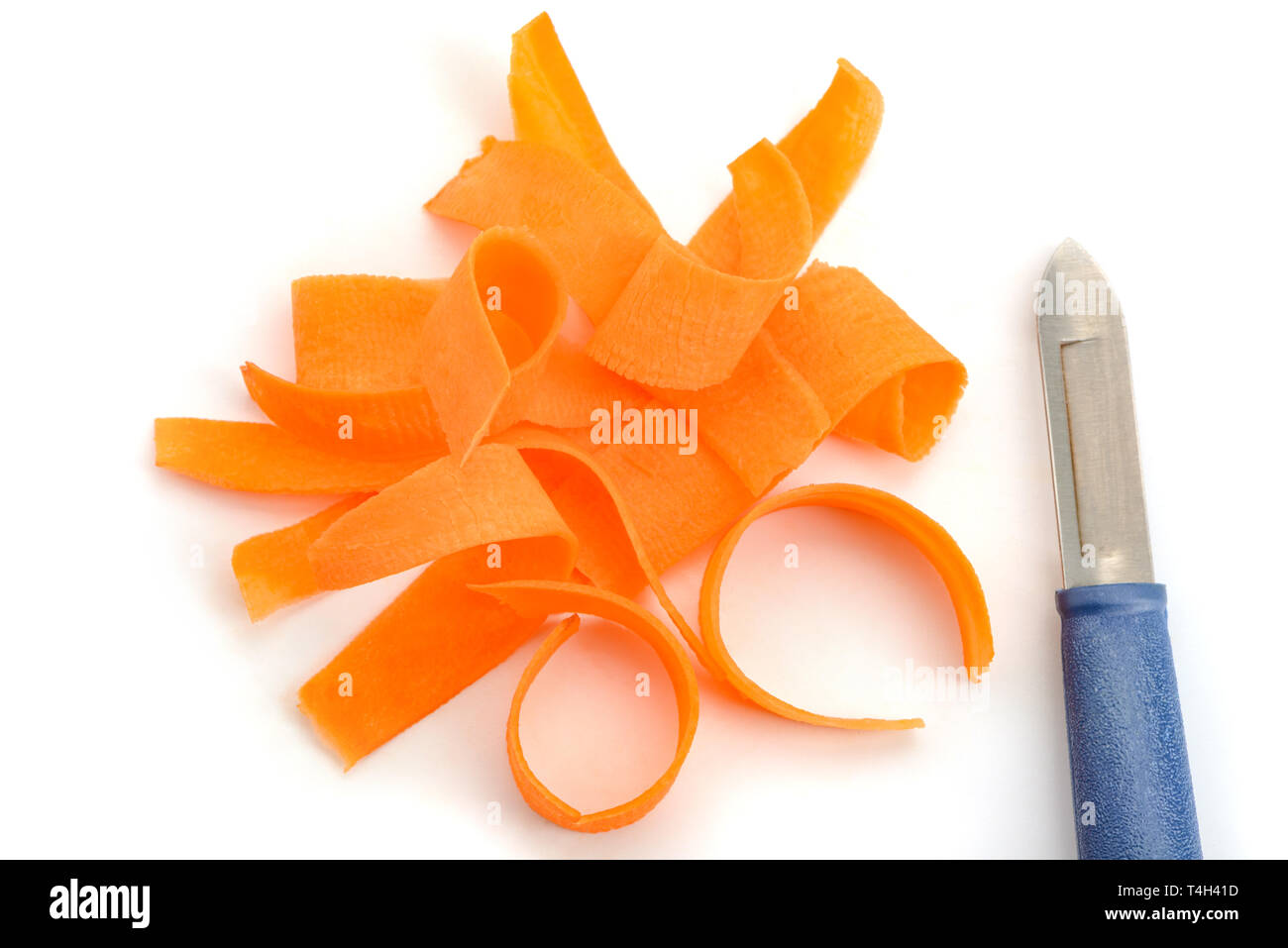 Carrot shavings and peeler knife on white background Stock Photo - Alamy