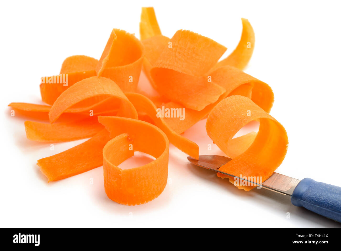 Carrot shavings and peeler knife on white background Stock Photo - Alamy