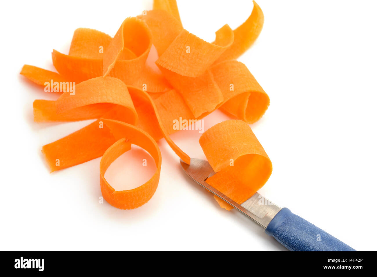 Carrot shavings and peeler knife on white background Stock Photo - Alamy