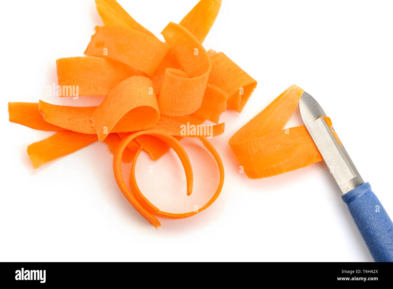 Carrot shavings and peeler knife on white background Stock Photo - Alamy