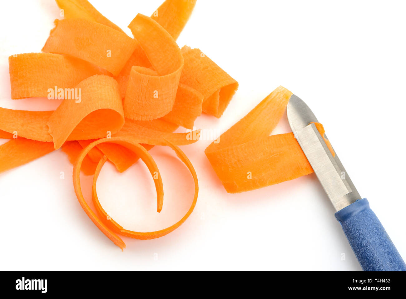 Carrot shavings and peeler knife on white background Stock Photo - Alamy