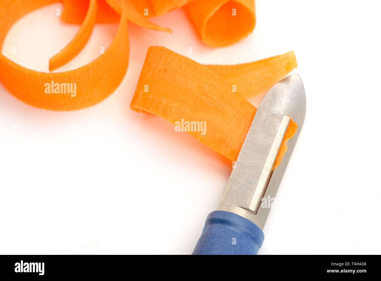 Carrot shavings and peeler knife on white background Stock Photo - Alamy
