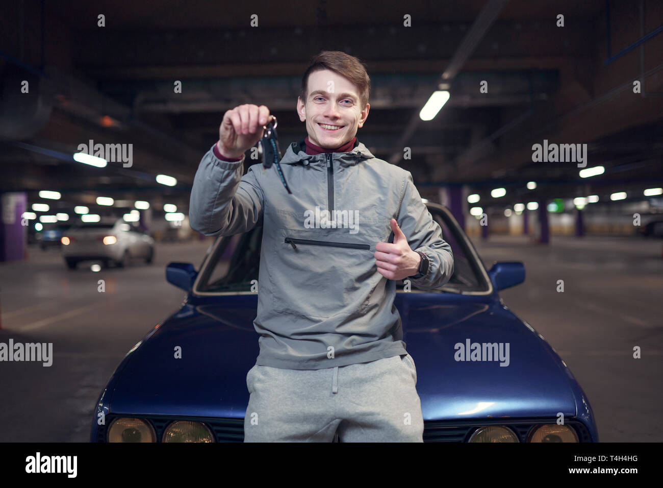 Photo of man with keys standing by car in underground parking Stock ...