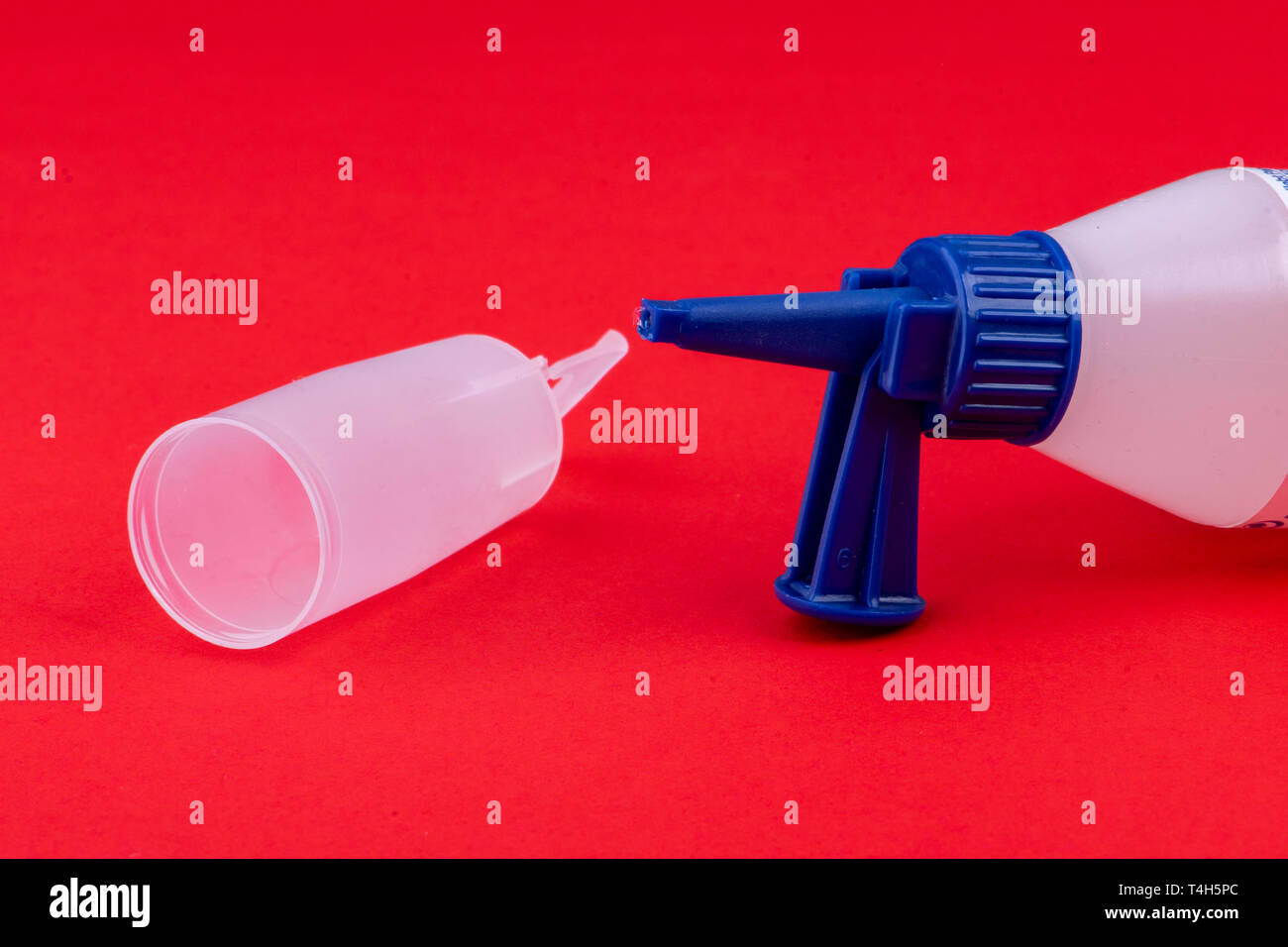 Adhesive tube with blue lid on white rustic wood background for craft ...