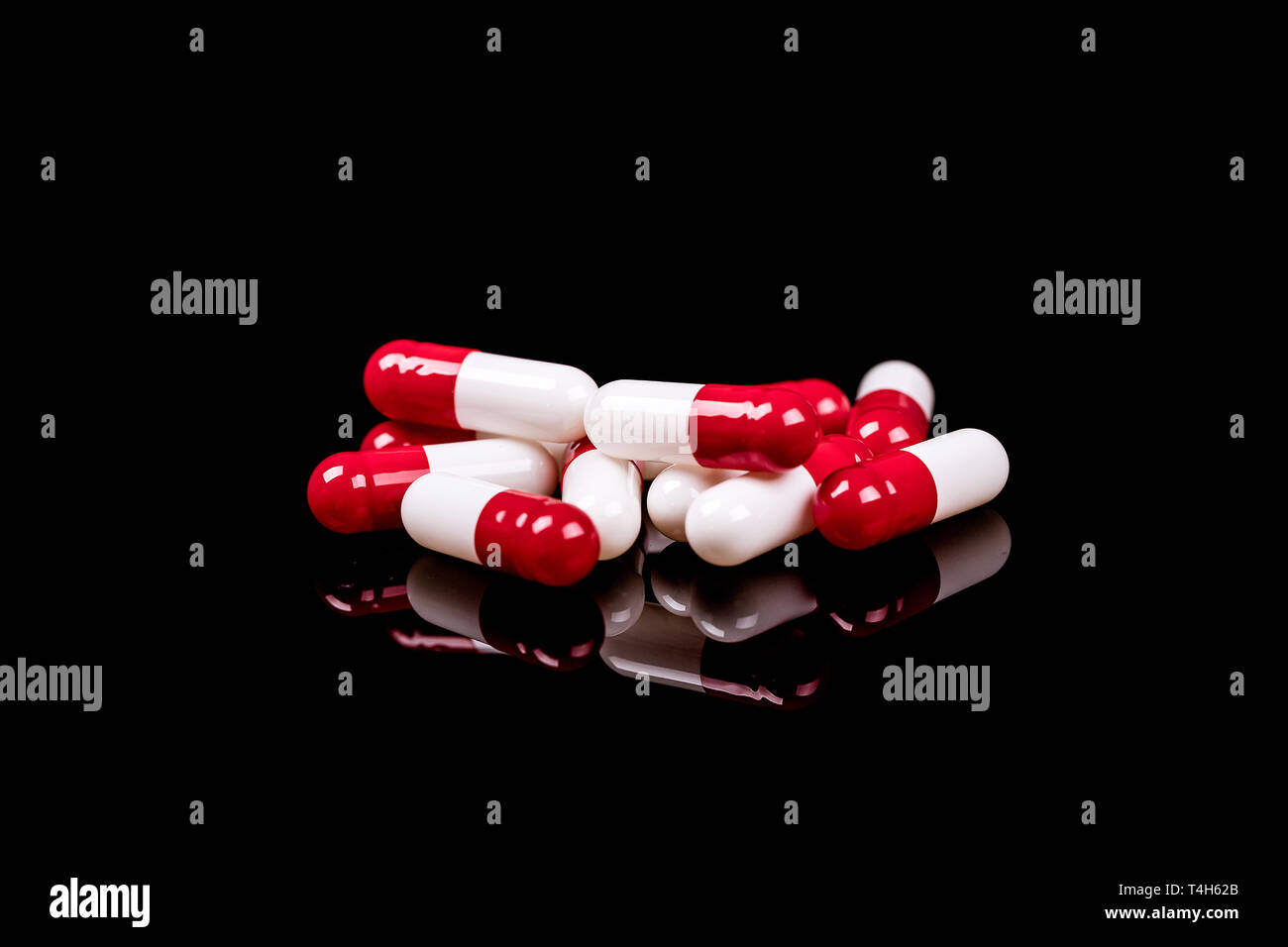 Closeup of white - red capsules isolated on black background. - Image ...