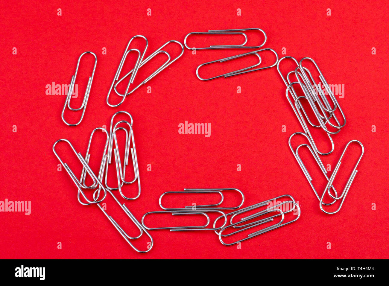 Paperclips laid in a circle on a red background Stock Photo - Alamy