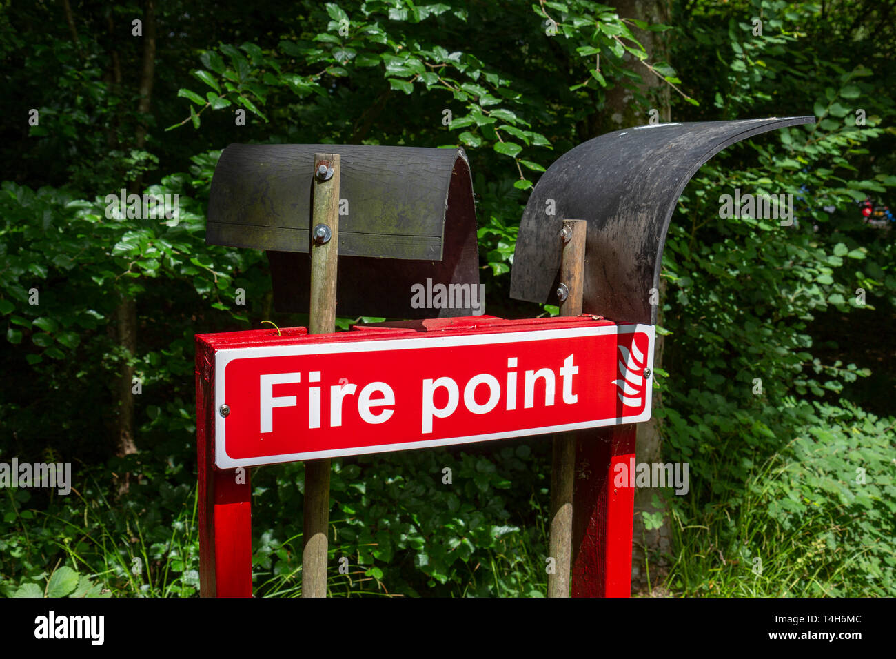 A camp site Fire Point consisting of a red metal frame with two fire ...
