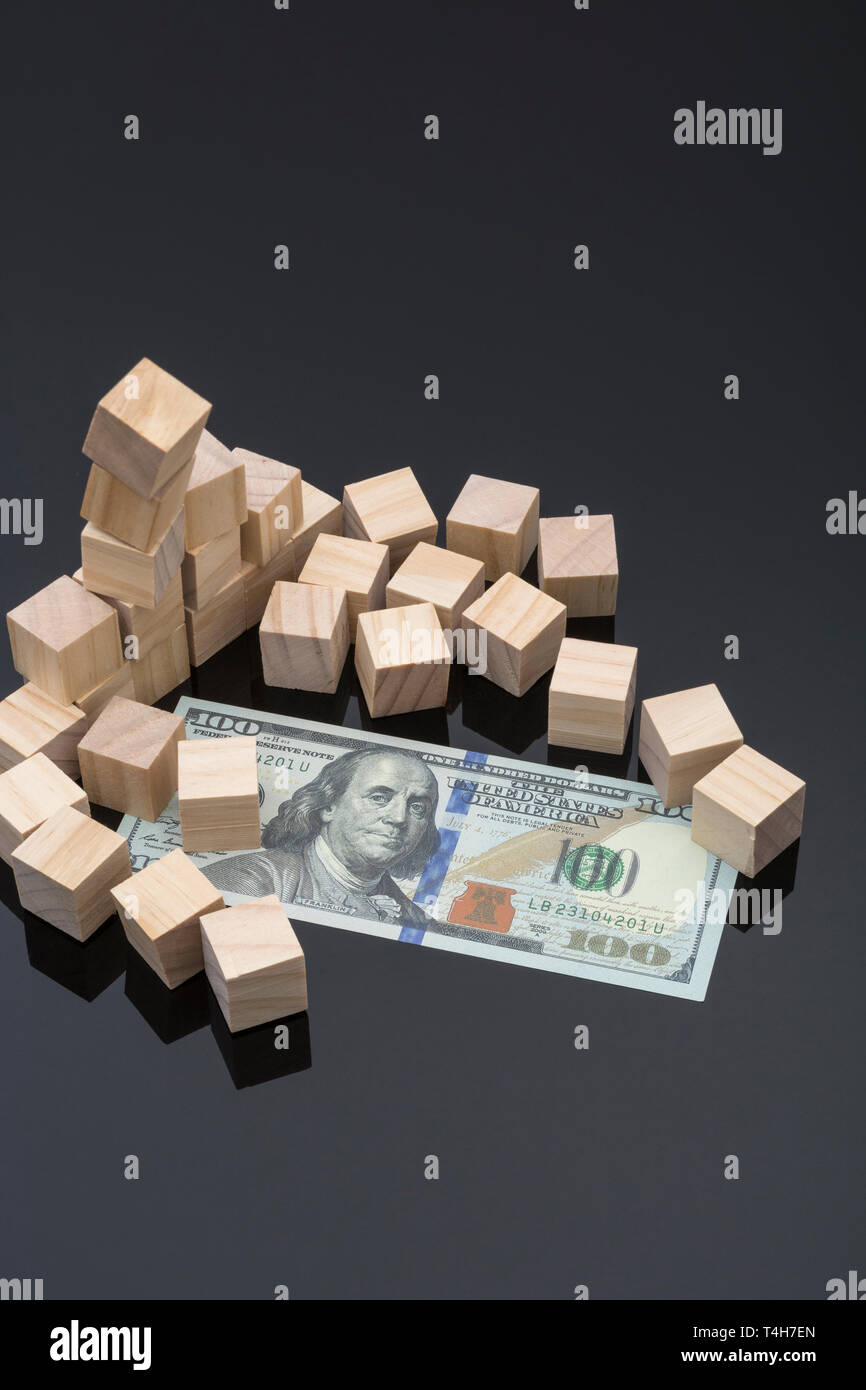 U.S. 100 Dollar bill with pile of wooden bricks. For Wall Street crash ...