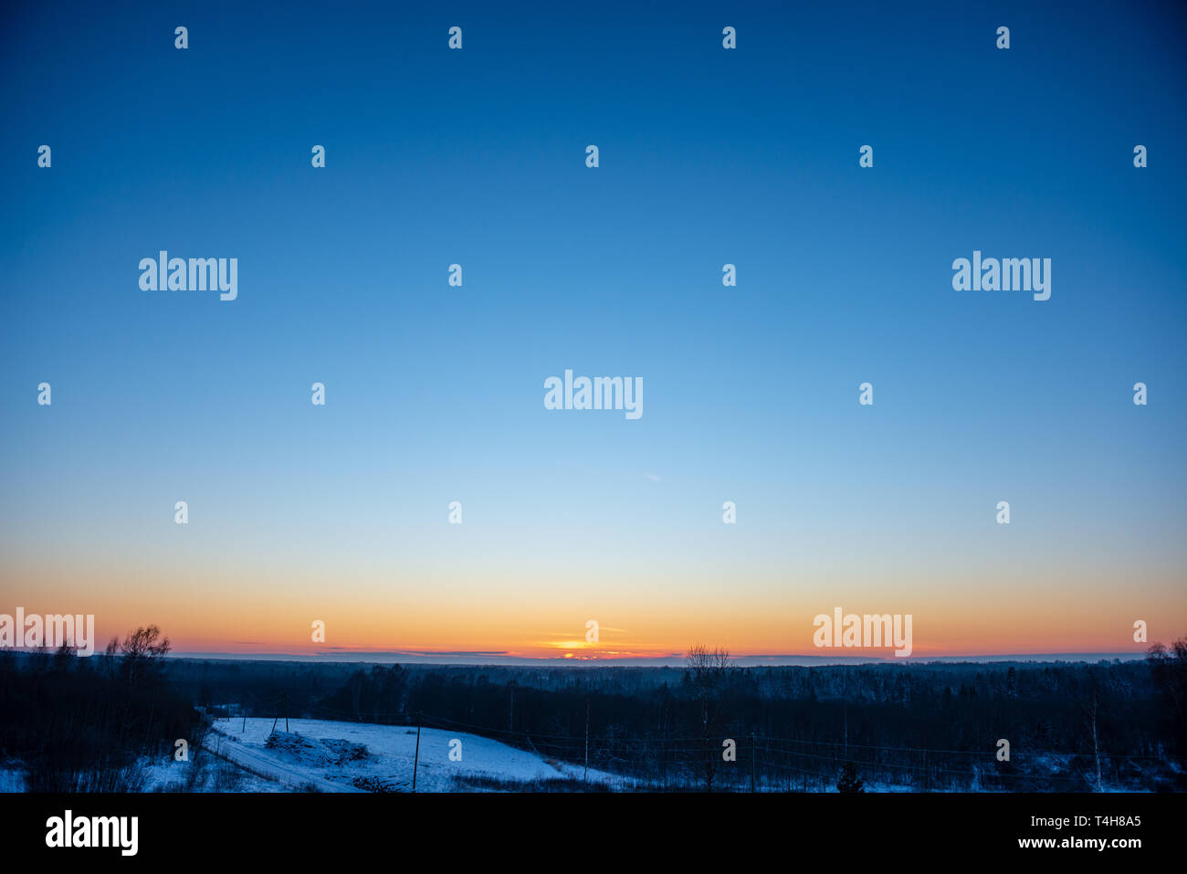 colorful sunset light over fields of snow in winter in countryside ...