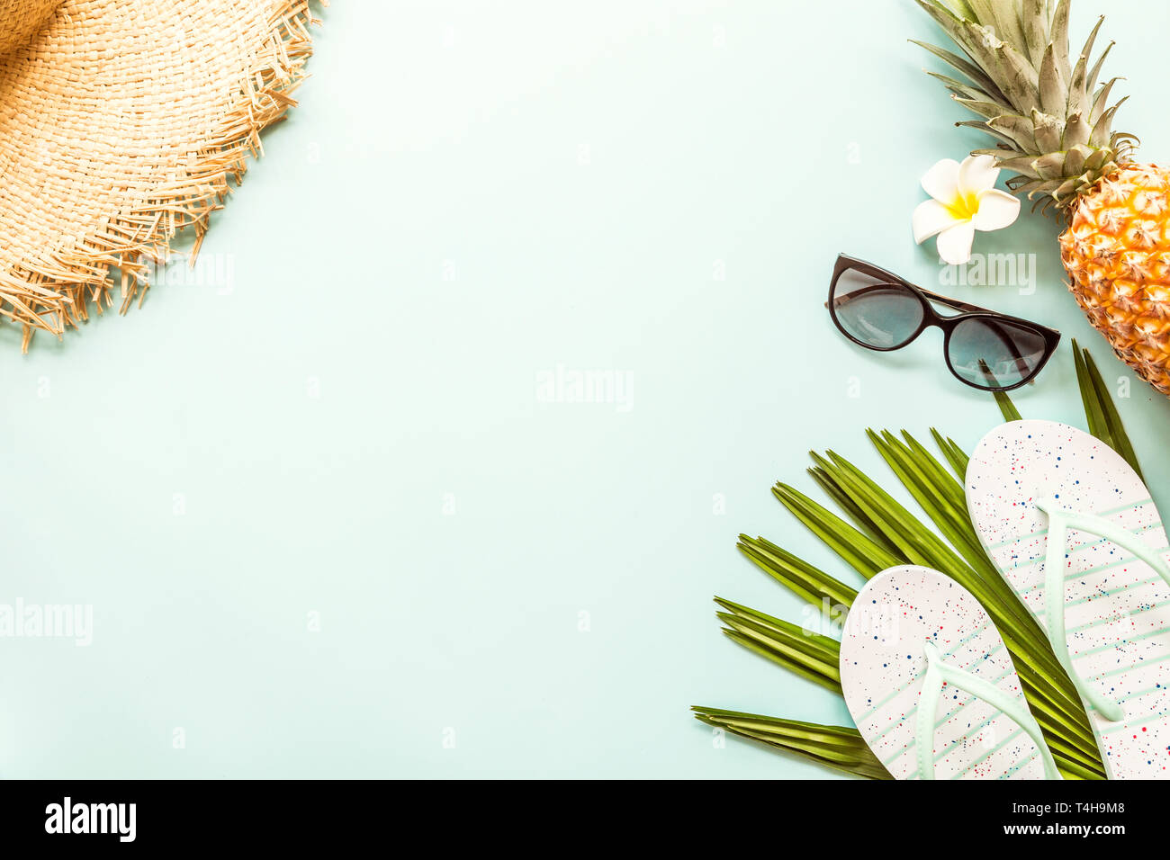 Travel flat lay items: fresh pineapple, straw hat, flower, sunglasses ...