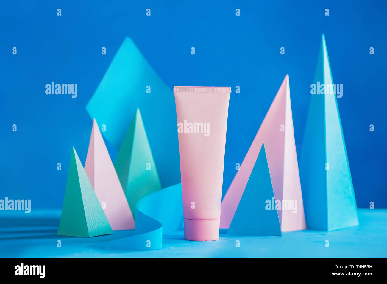Cosmetics and skin care design with pink tubes and modern paper ...