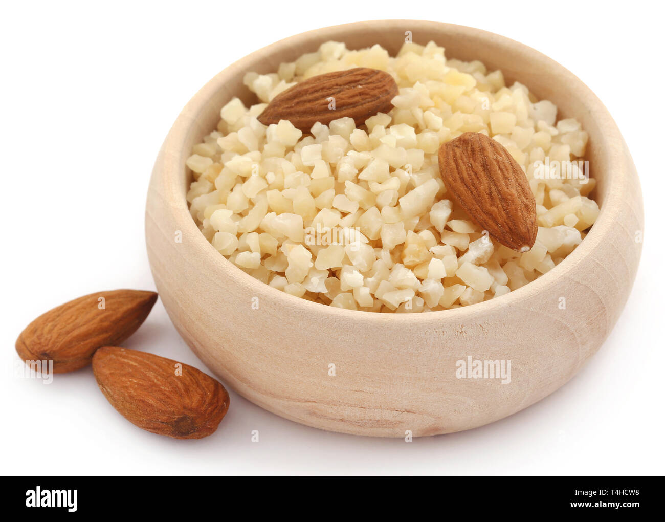 Small pieces of chopped almonds with whole ones over white background ...