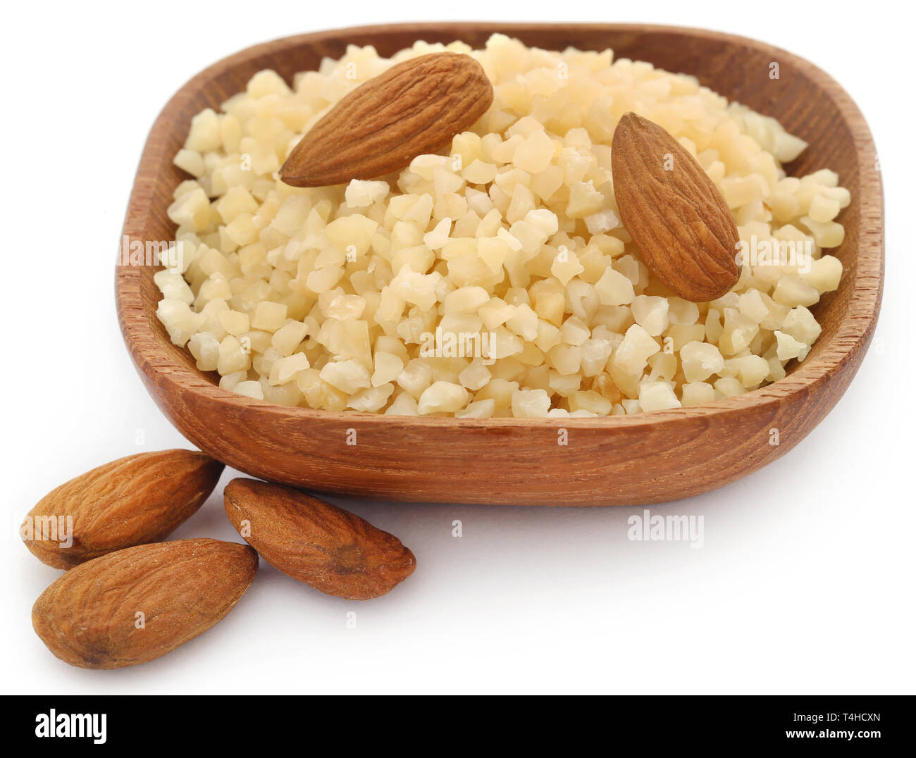 Small pieces of chopped almonds with whole ones over white background ...