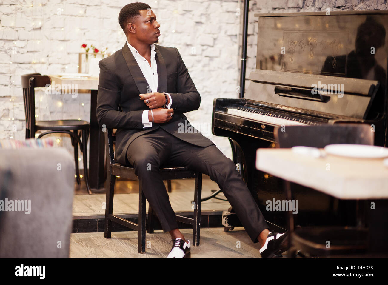 Strong powerful african american man in black suit sitting against ...