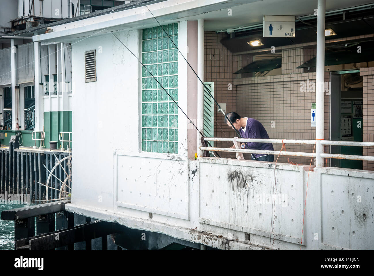 Unidentified fisherman at the Tsim Sha Tsui's Star ferry deck. Chinese ...