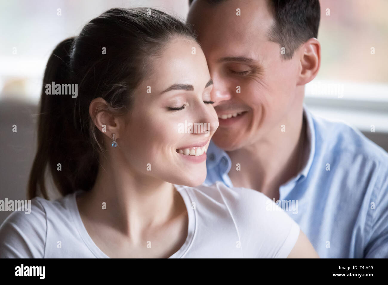 Happy family couple hug each other with eyes closed Stock Photo - Alamy
