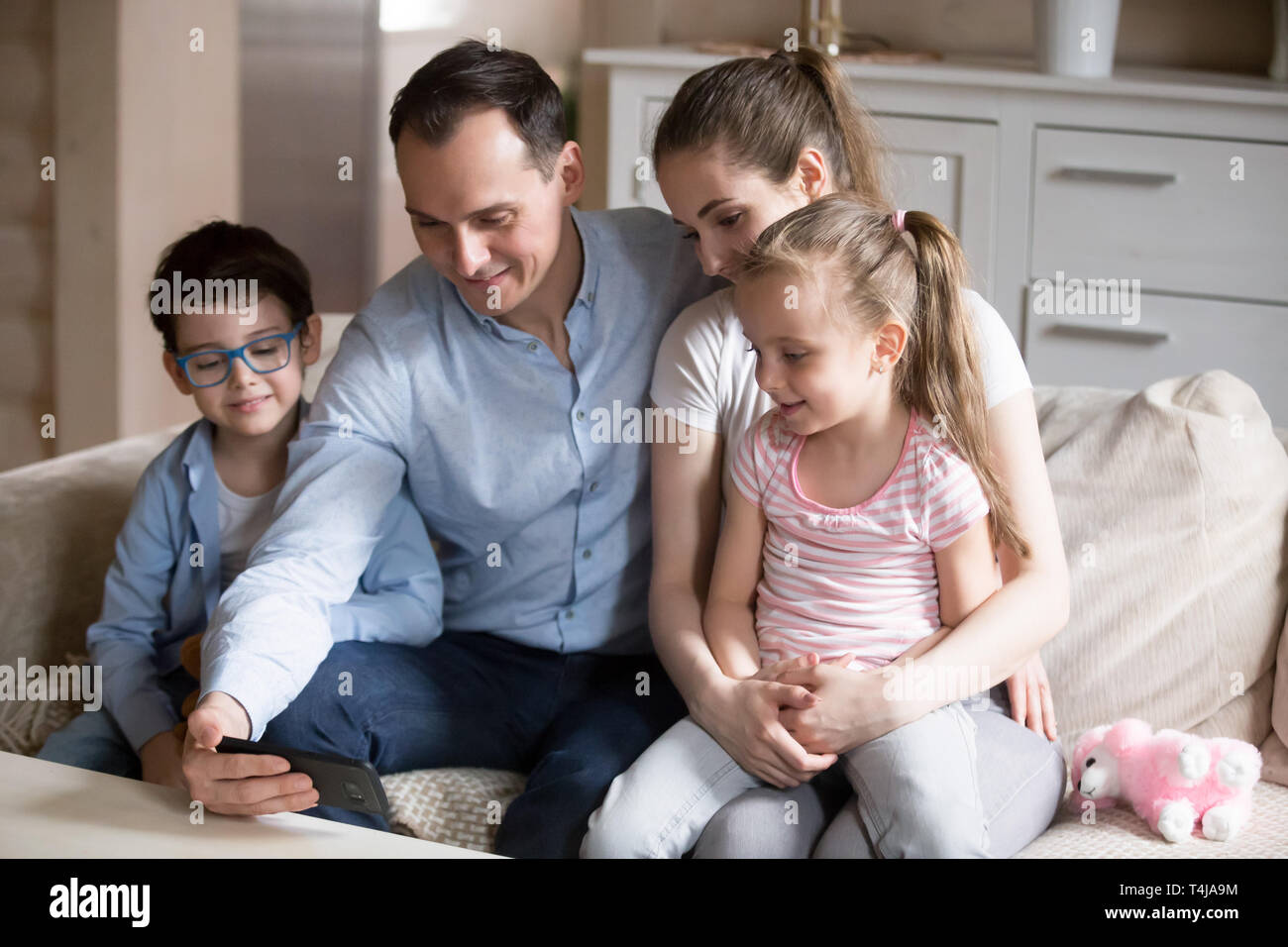 Whole family watching funny video on smartphone at home Stock Photo - Alamy