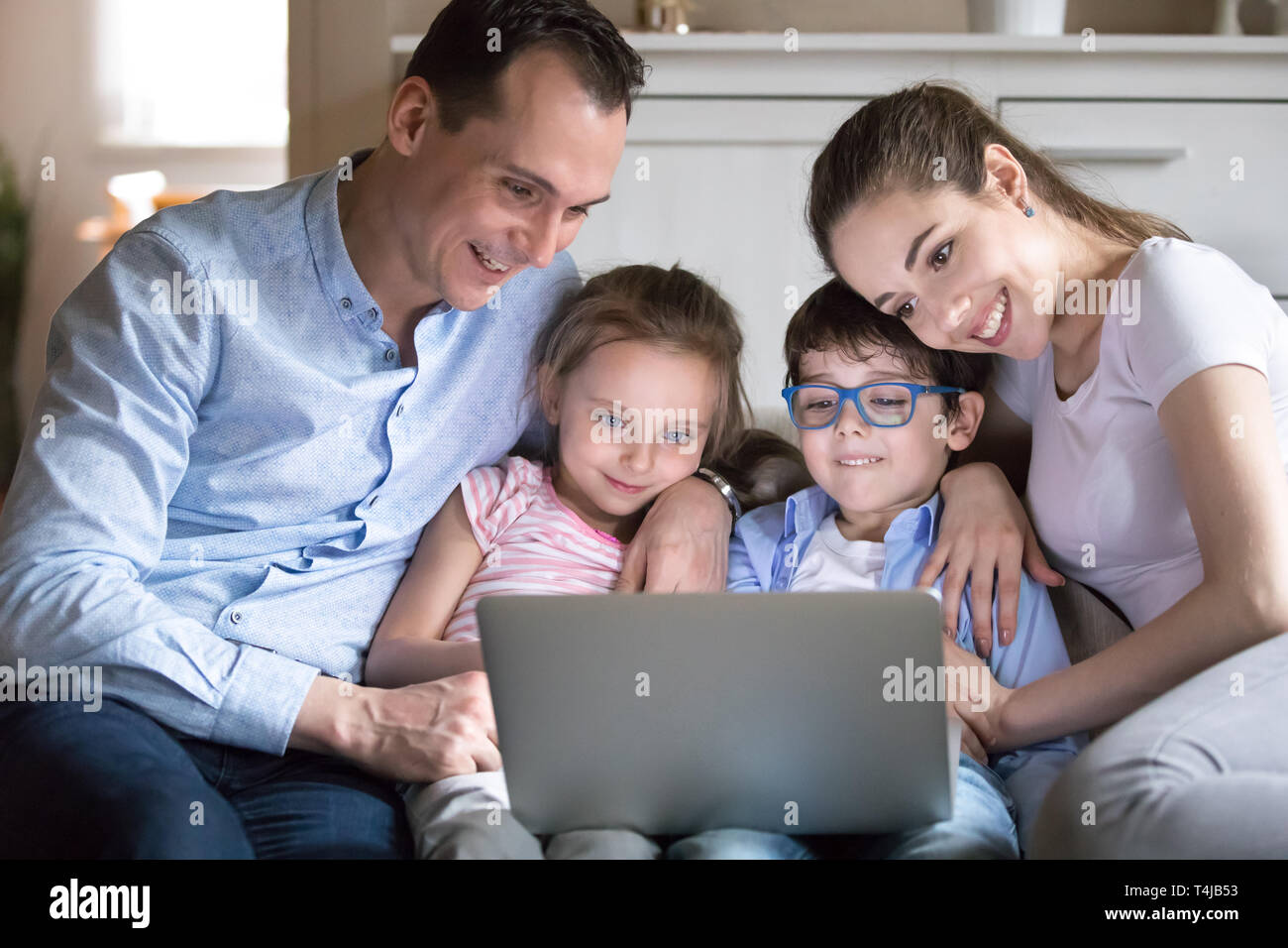 Happy family with kids watching funny video on computer screen Stock ...