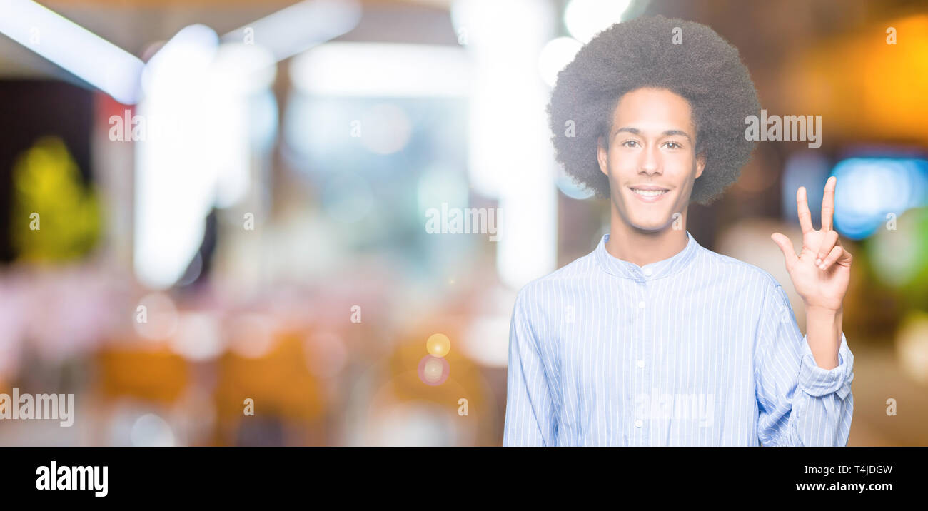 Young african american man with afro hair showing and pointing up with ...