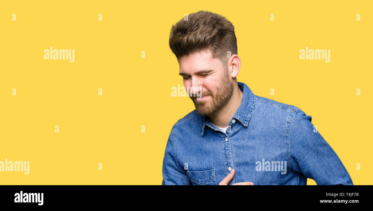Young handsome blond man wearing casual denim shirt with hand on ...