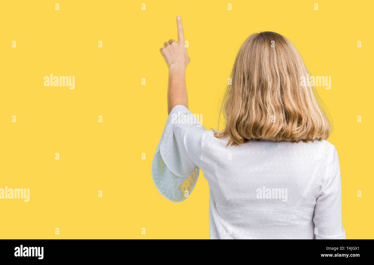 Beautiful young elegant woman over isolated background Posing backwards ...