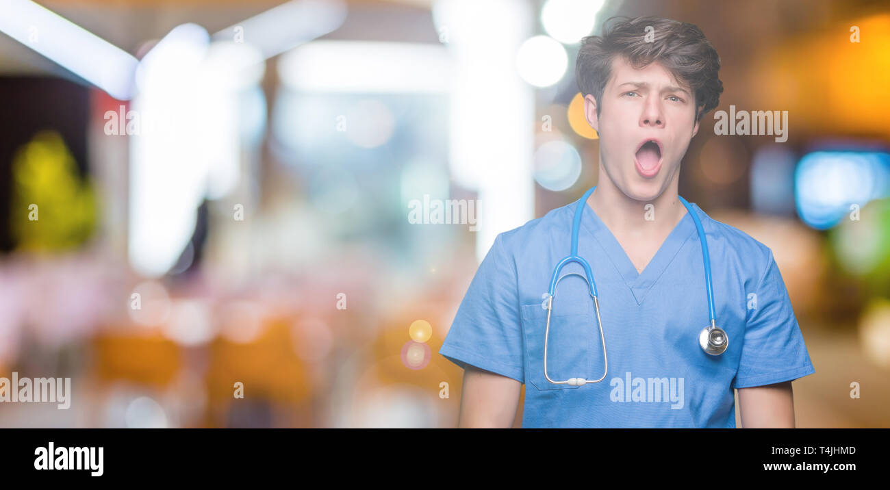 Young doctor wearing medical uniform over isolated background In shock ...