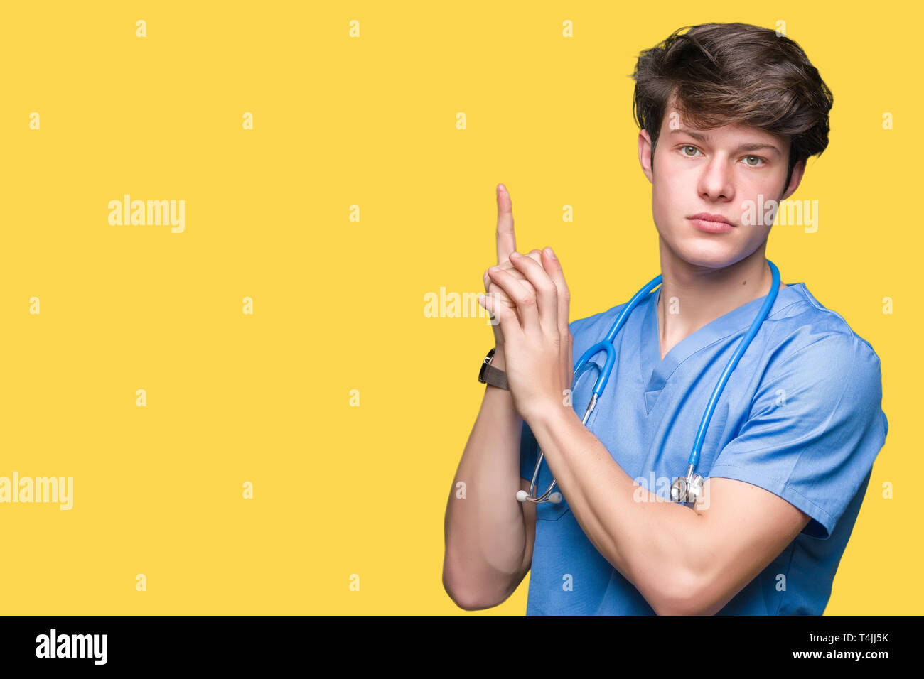 Young doctor wearing medical uniform over isolated background Holding ...