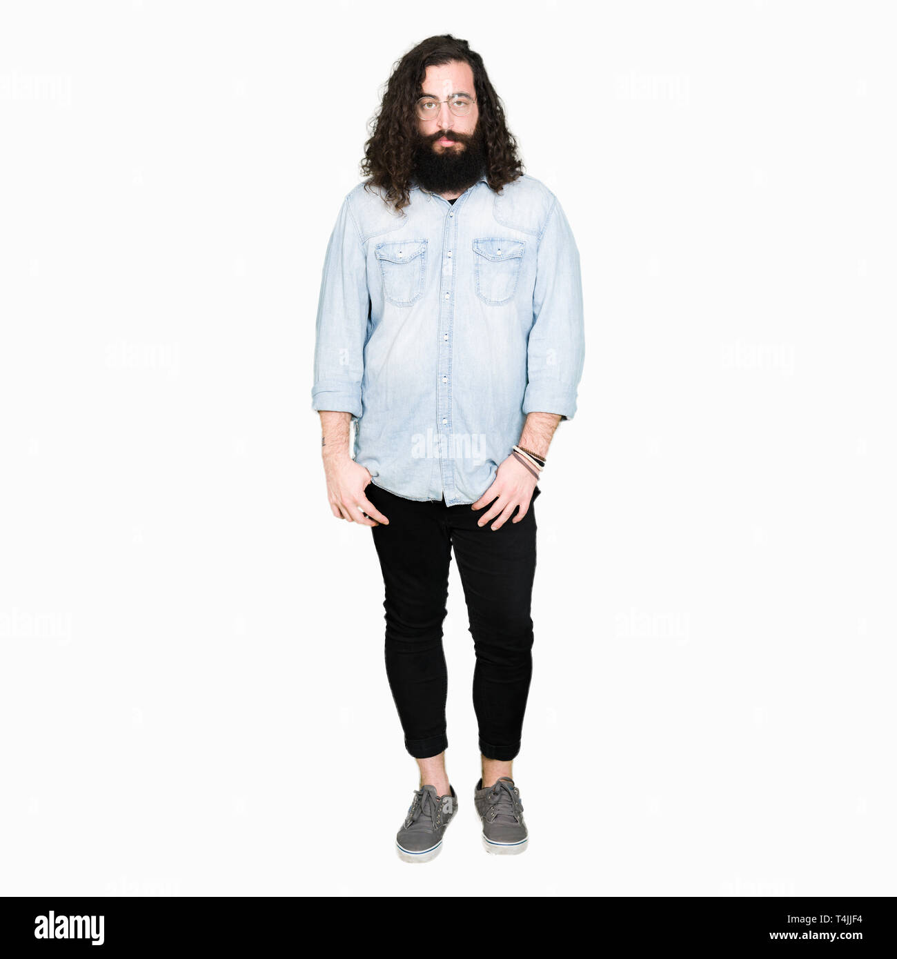 Young hipster man with long hair and beard wearing glasses depressed ...