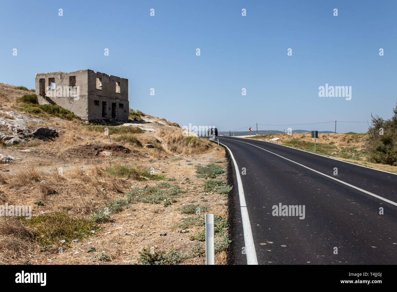 an antique stone building at a hill of mountain and road. photo has ...