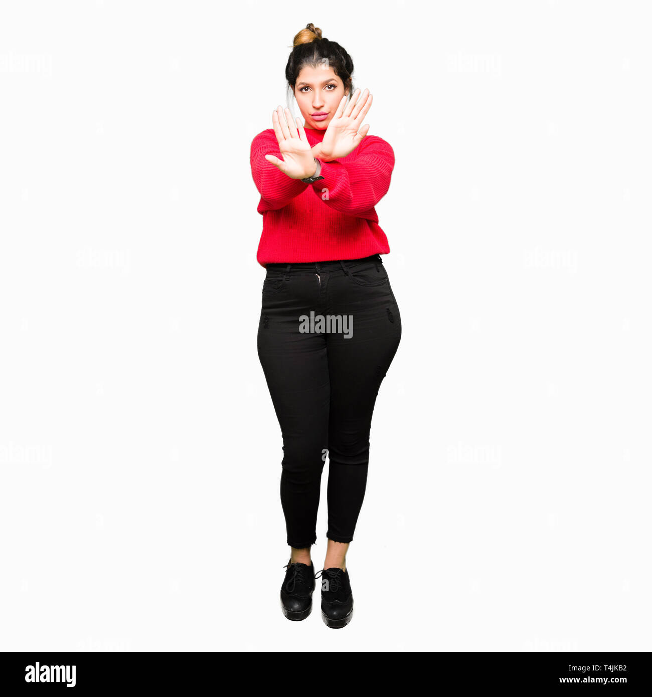 Young beautiful woman wearing red sweater and bun Rejection expression ...