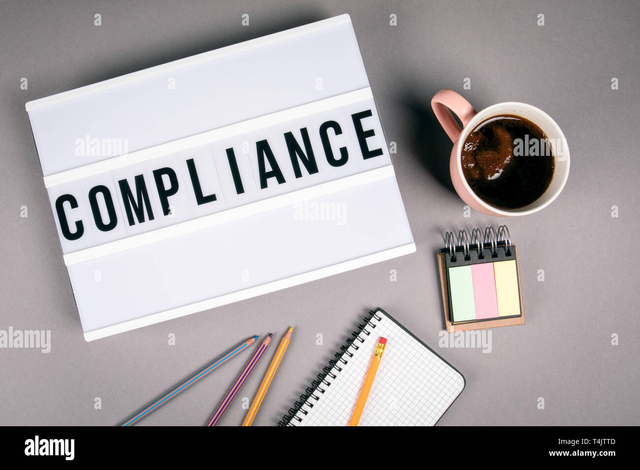 Compliance. Text in light box. Pink coffee mug on gray background Stock ...