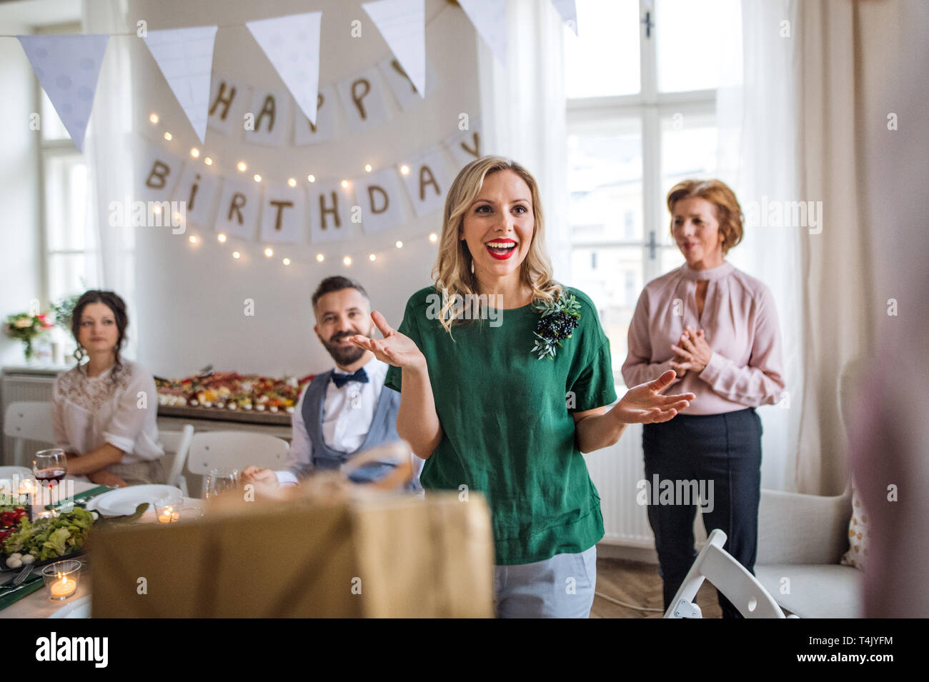 Happy surprised young woman receiving a gift on indoor party Stock ...