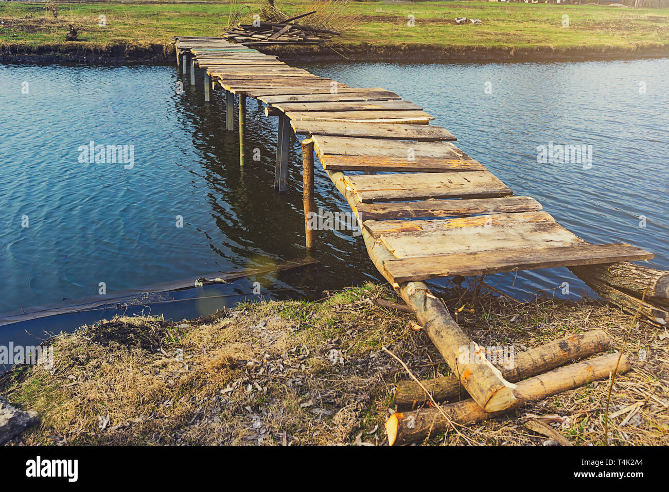 wooden bridge across the river. the old bridge of wooden flooring over ...
