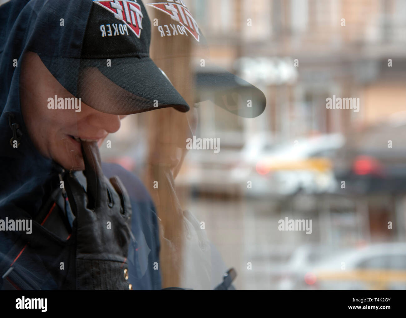Photo of a girl in a baseball cap, which holds a glove in his teeth ...