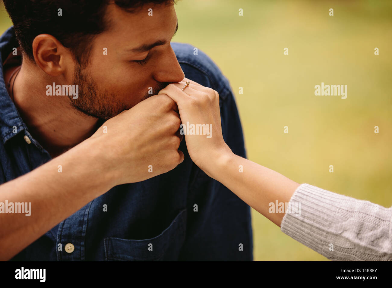 Newly engaged couple. Close up of a young man kissing woman's hand ...