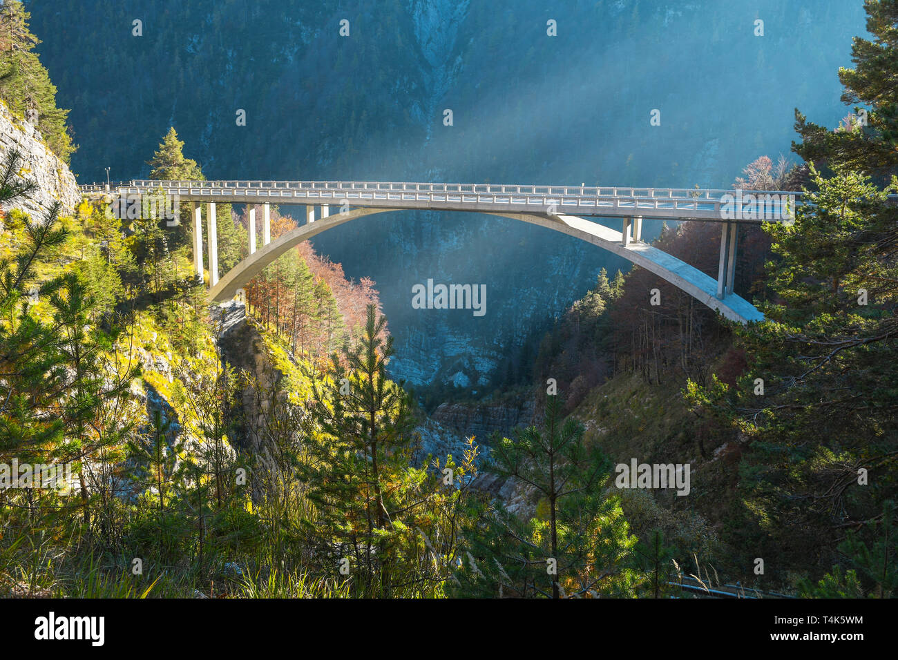 Bow shaped bridge over the river close to a road that is headed to ...