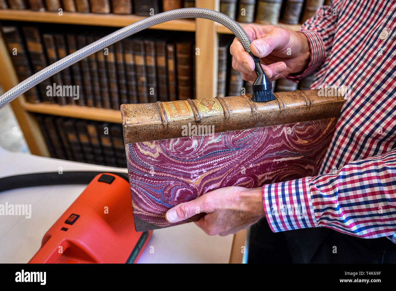 Salisbury cathedral library volunteer Colin Malcolm uses a special ...